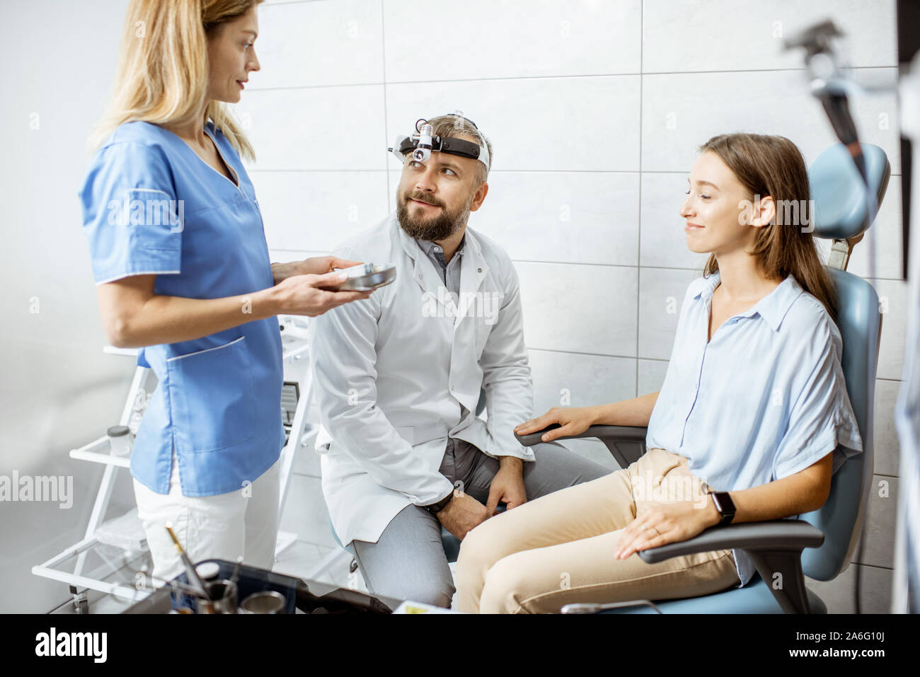 Patient with senior otolaryngologist and female assistant in ENT office ...