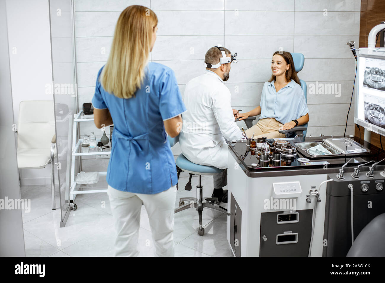 Patient with senior otolaryngologist and female assistant in ENT office ...