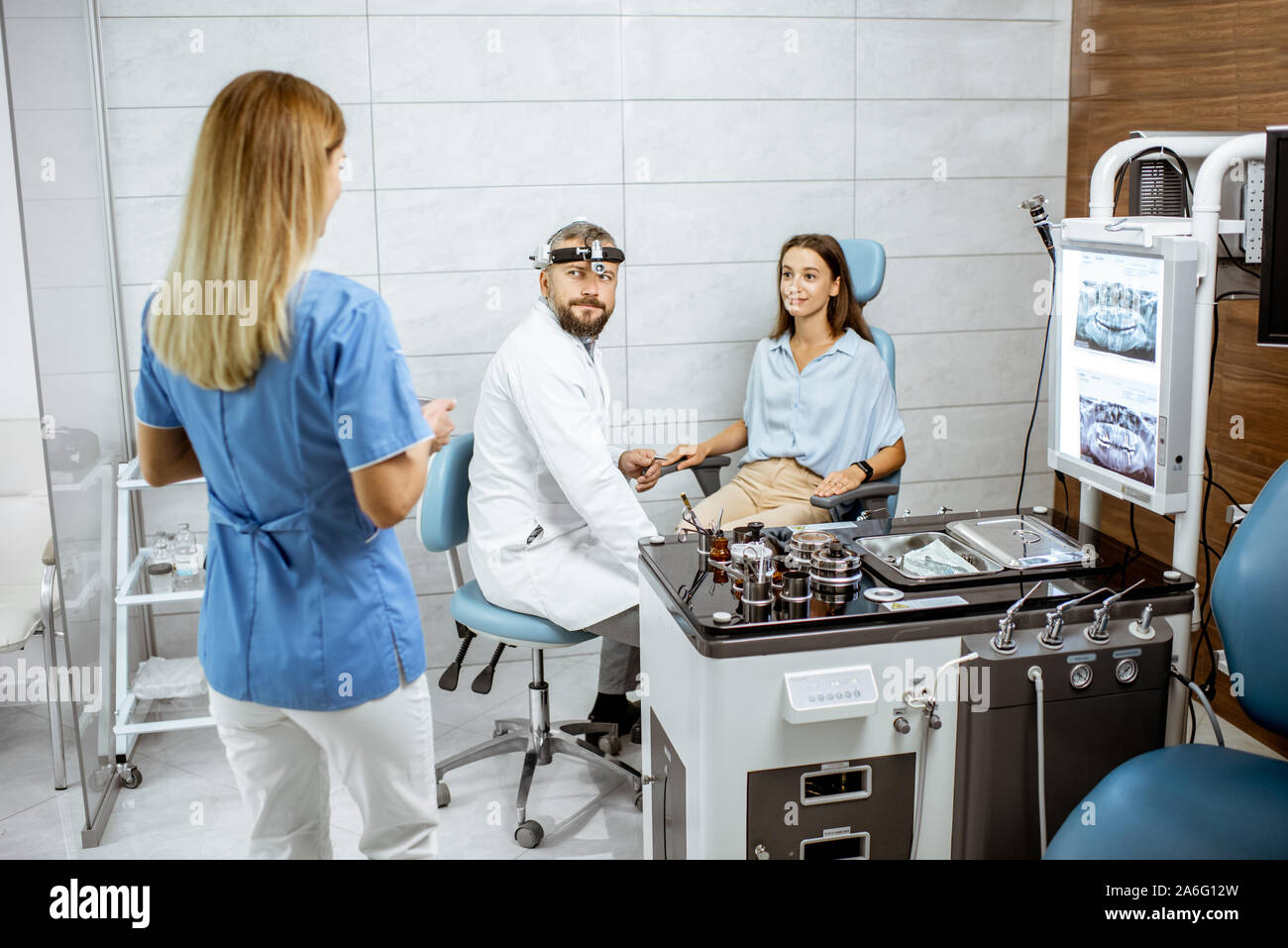 Patient with senior otolaryngologist and female assistant in ENT office ...