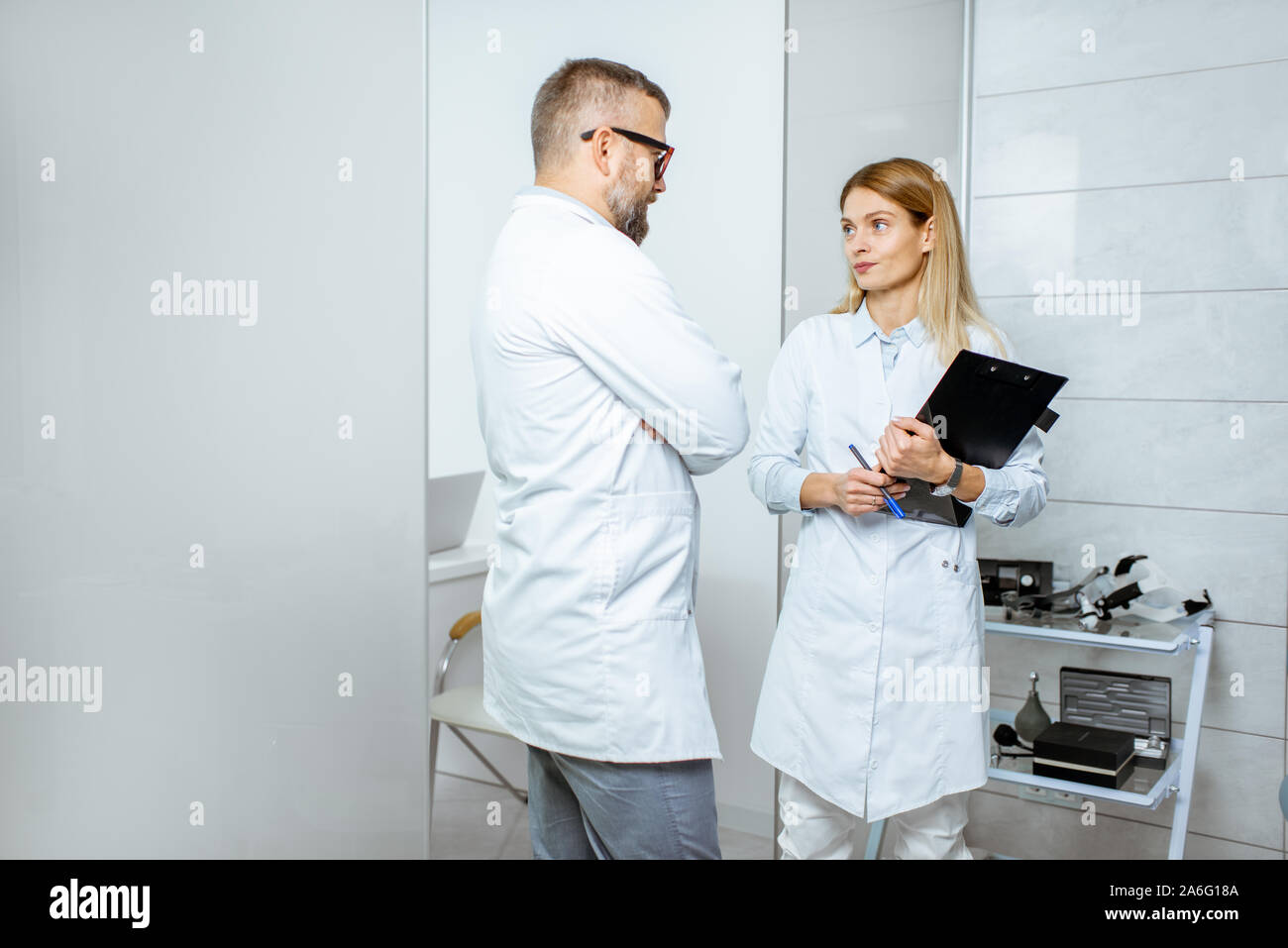 Two senior doctors talking while standing together in the hospital ...