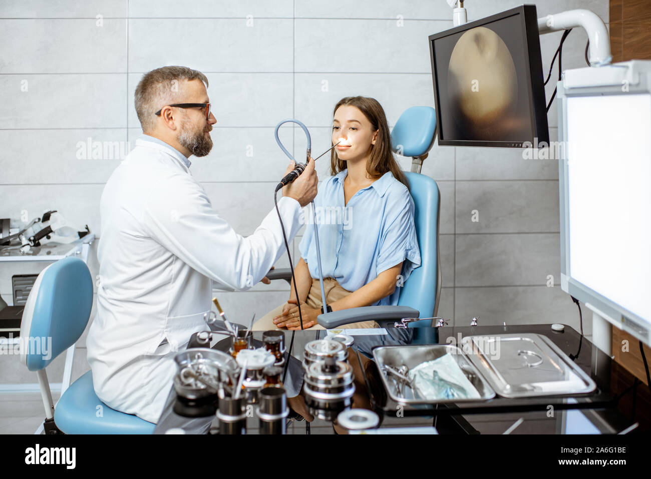 Senior otolaryngologist making endoscopic examination of a nose for a ...