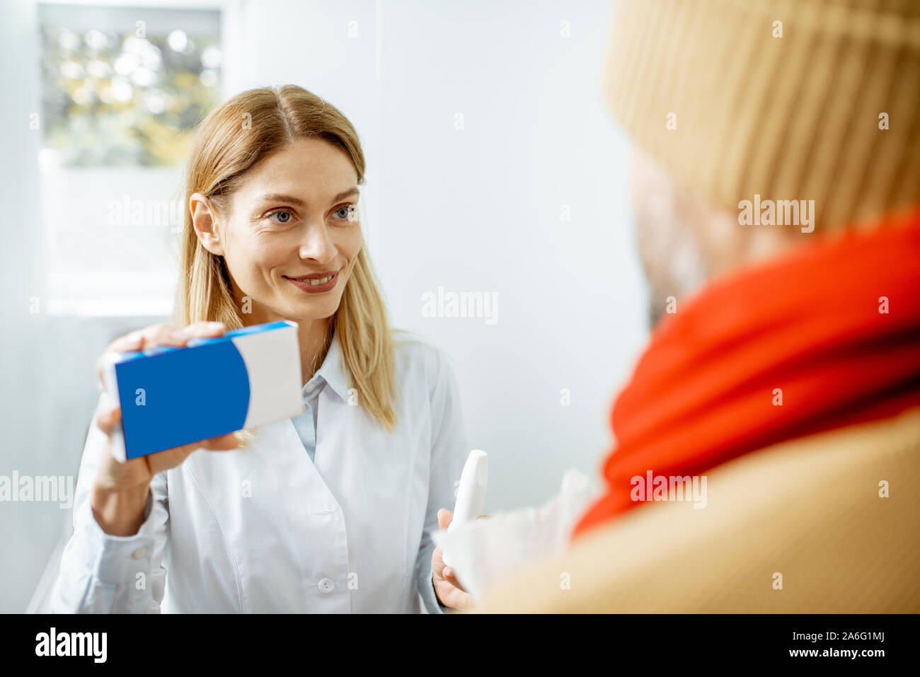 Doctor offering some anti-cold remedies for a sick man during a medical ...