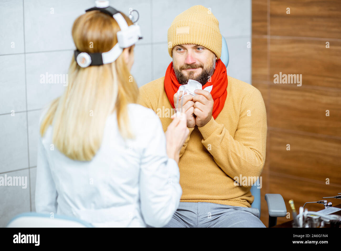 Adult patient catching cold, sitting in warm clothes with runny nose ...