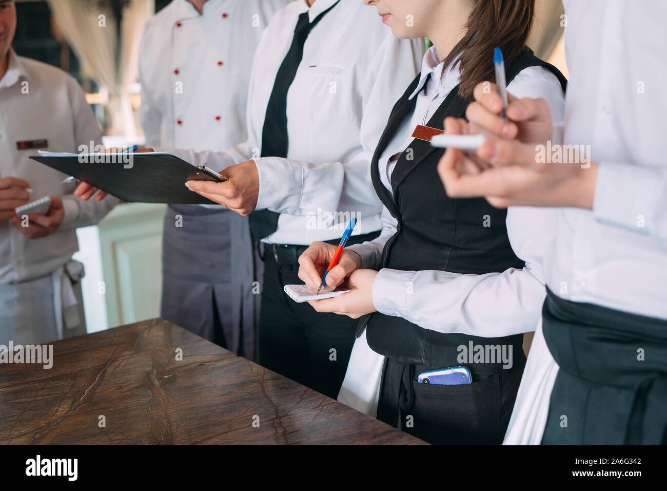 Restaurant manager and his staff in terrace. interacting to head chef ...