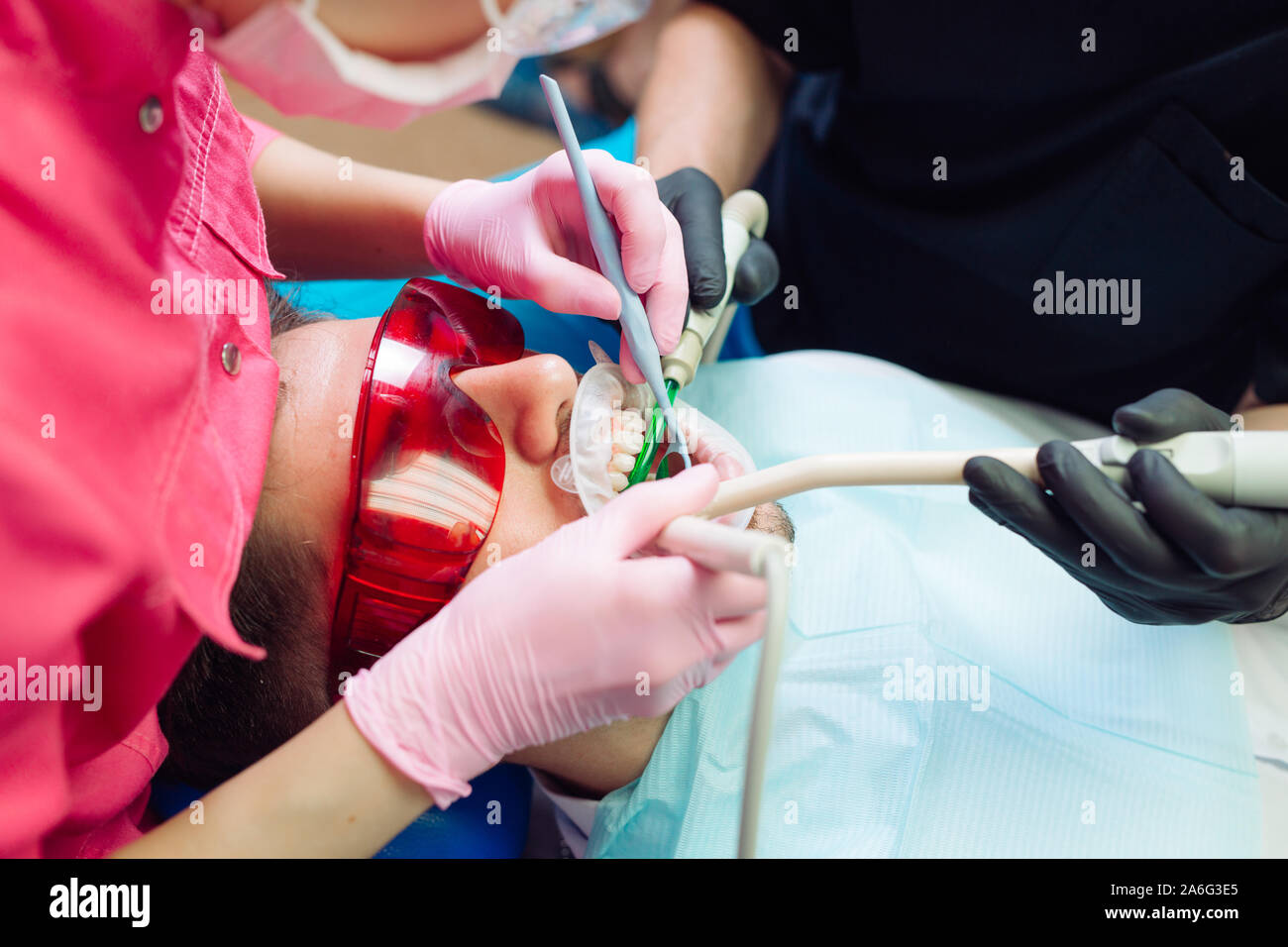 Professional teeth cleaning. Dentist cleans the teeth of a male patient ...