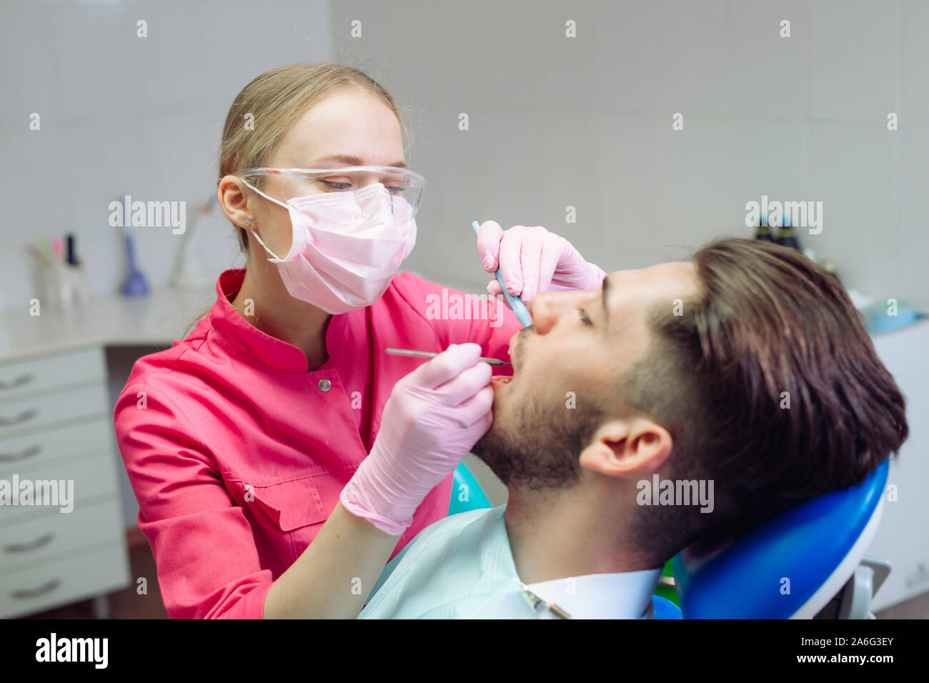 Professional teeth cleaning. Dentist cleans the teeth of a male patient ...
