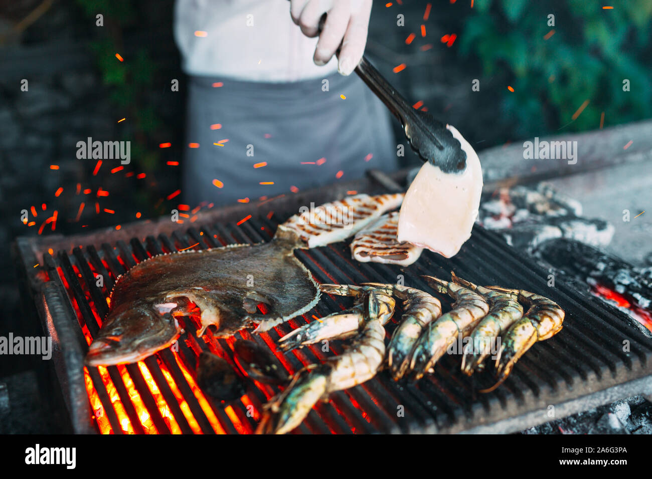 Seafood on the grill. Mussels, shrimp, squid and fish are cooked on ...