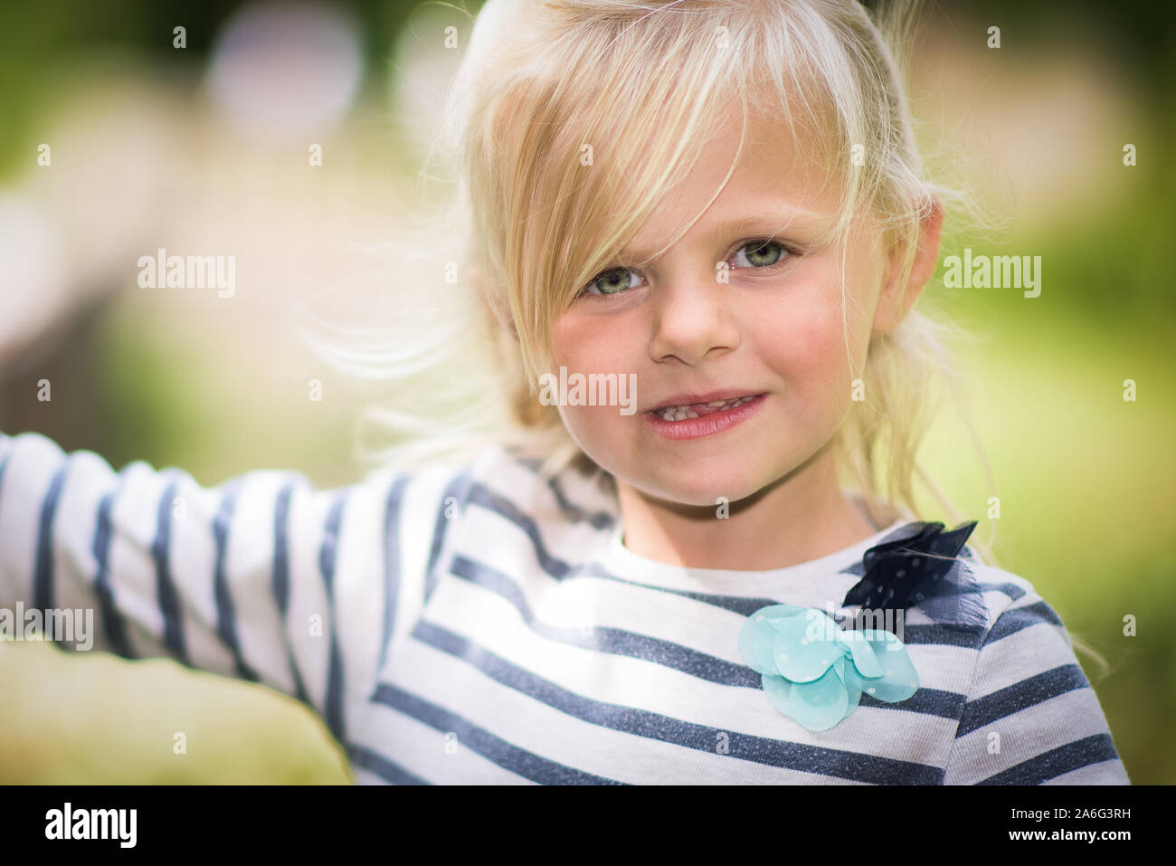 A cute very pretty little blonde 6 year old girl smiles nicely and ...