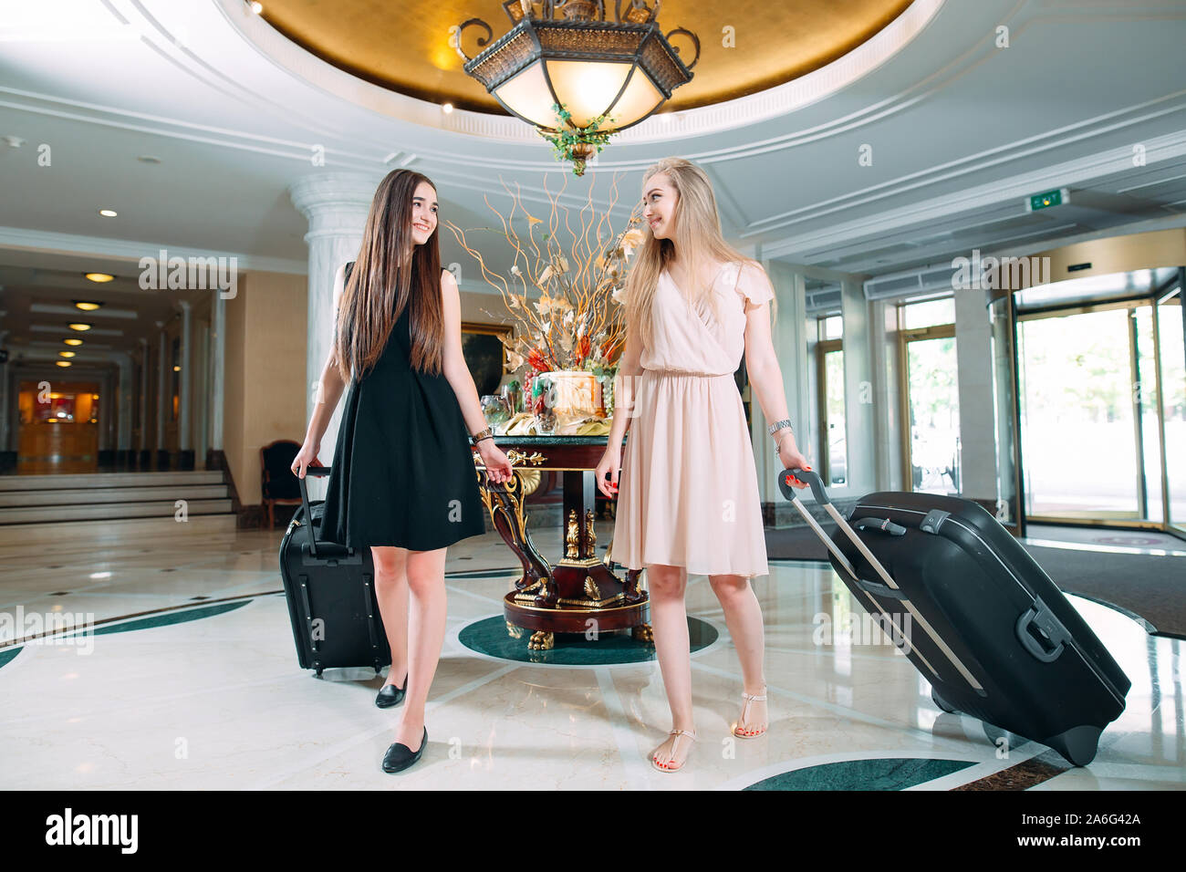 Young girls near reception desk in hotel. Young girls comes to the ...
