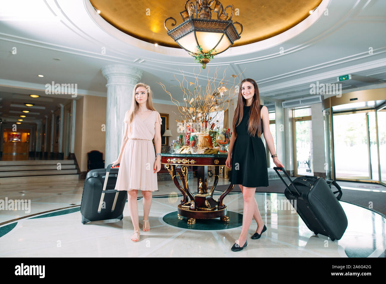 Young girls near reception desk in hotel. Young girls comes to the ...