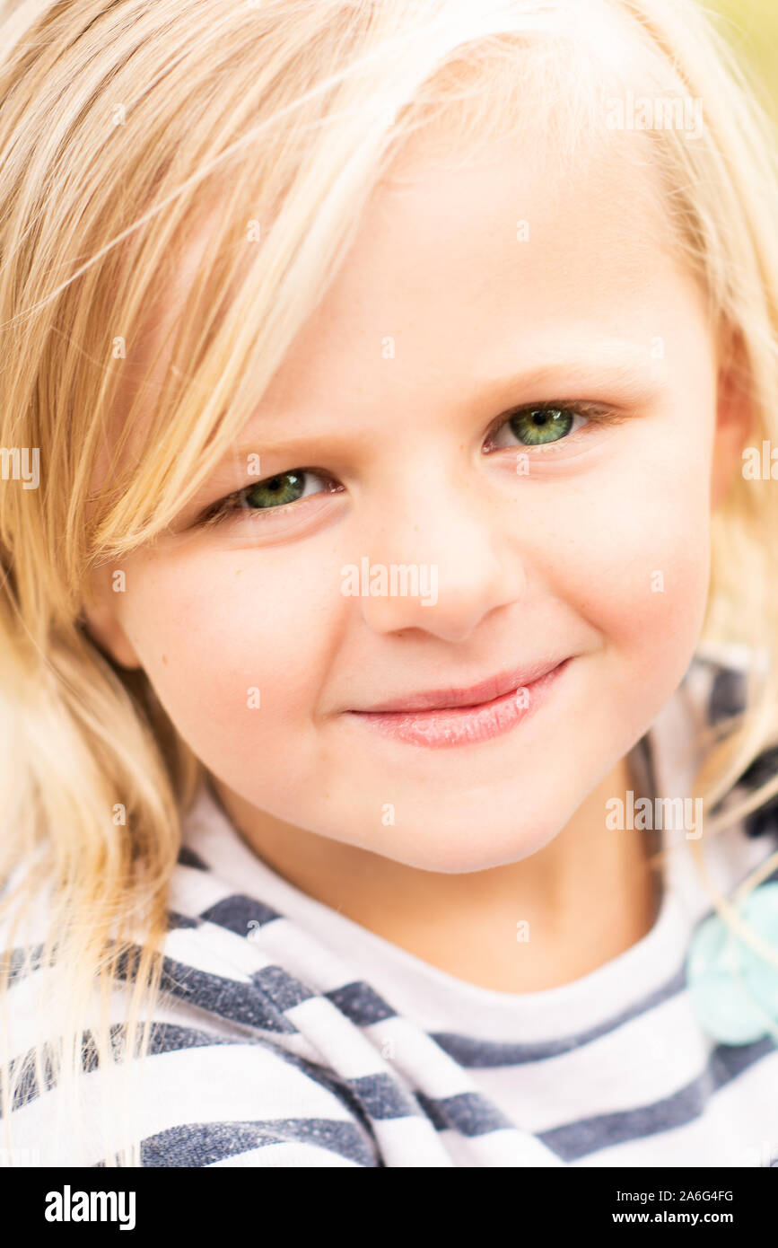 A cute very pretty little blonde 6 year old girl smiles nicely and ...