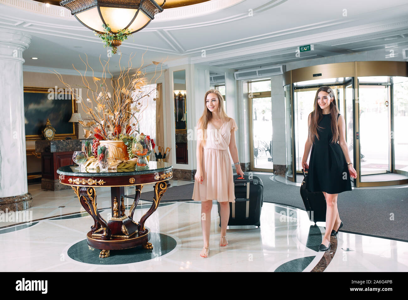 Young girls near reception desk in hotel. Young girls comes to the ...