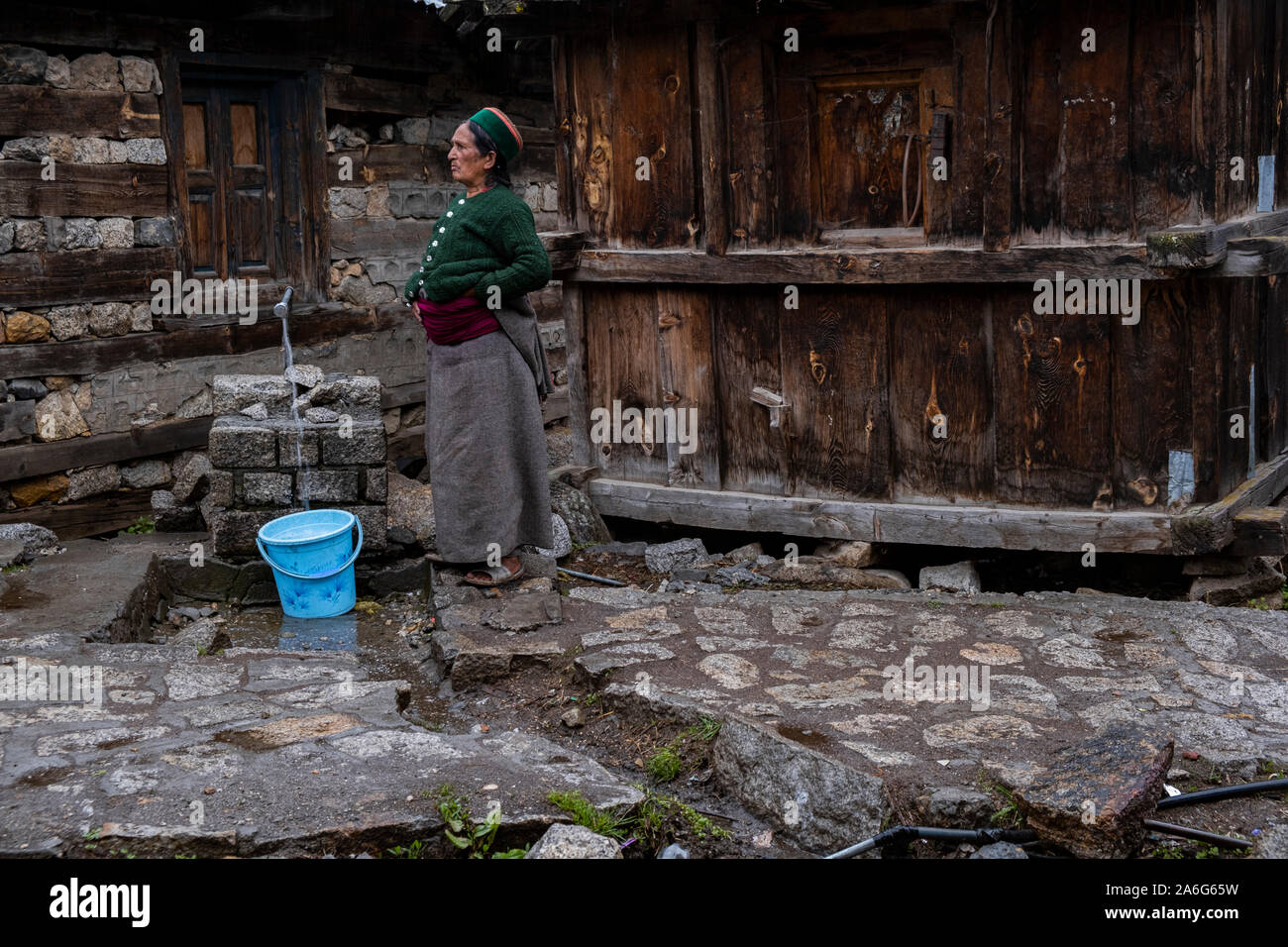 Old woman filling bucket water hi-res stock photography and images - Alamy