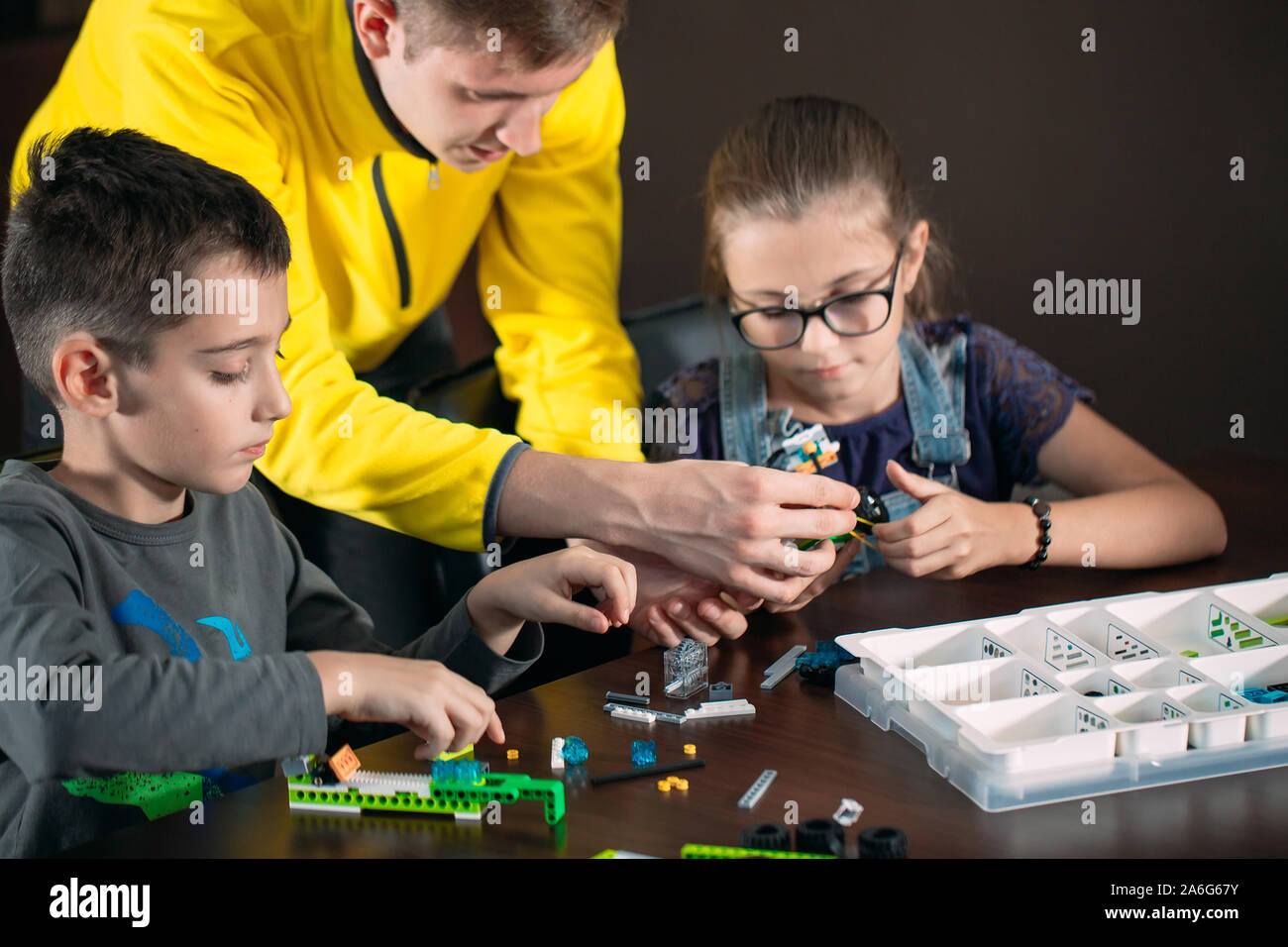 Kids creating robots with teacher. Early development, diy, innovation ...