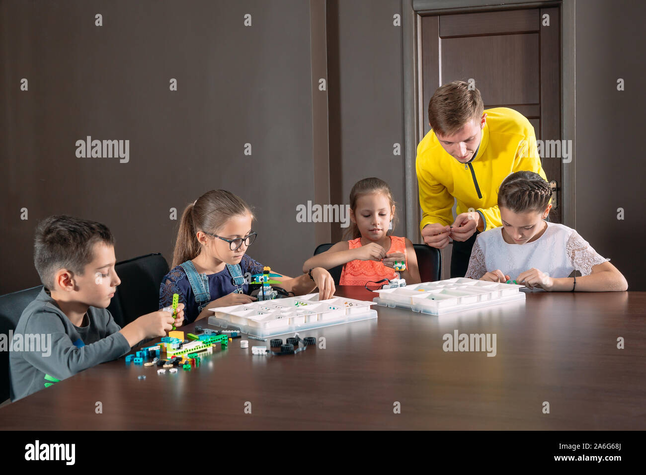 Kids creating robots with teacher. Early development, diy, innovation ...