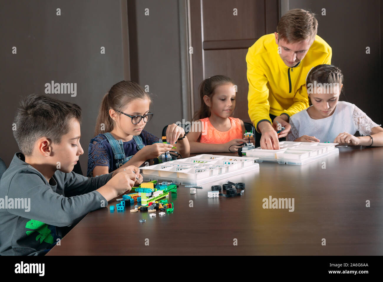 Kids creating robots with teacher. Early development, diy, innovation ...