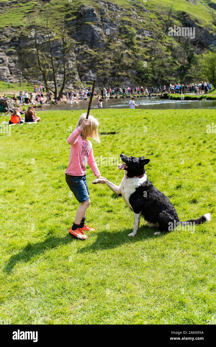 A pretty little girl plays with her dog by the famous Dovedale Stepping ...