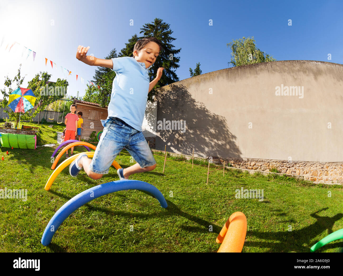 Happy boy play competitive game jump over barriers Stock Photo - Alamy