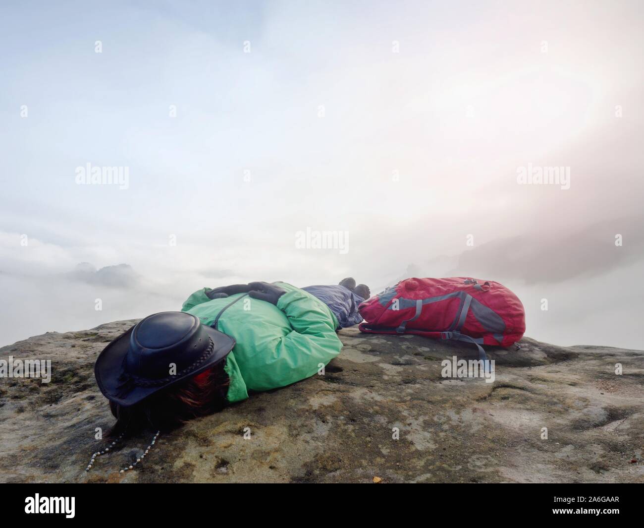 Woman tourist lays on top of the word above heavy clouds and dreams ...