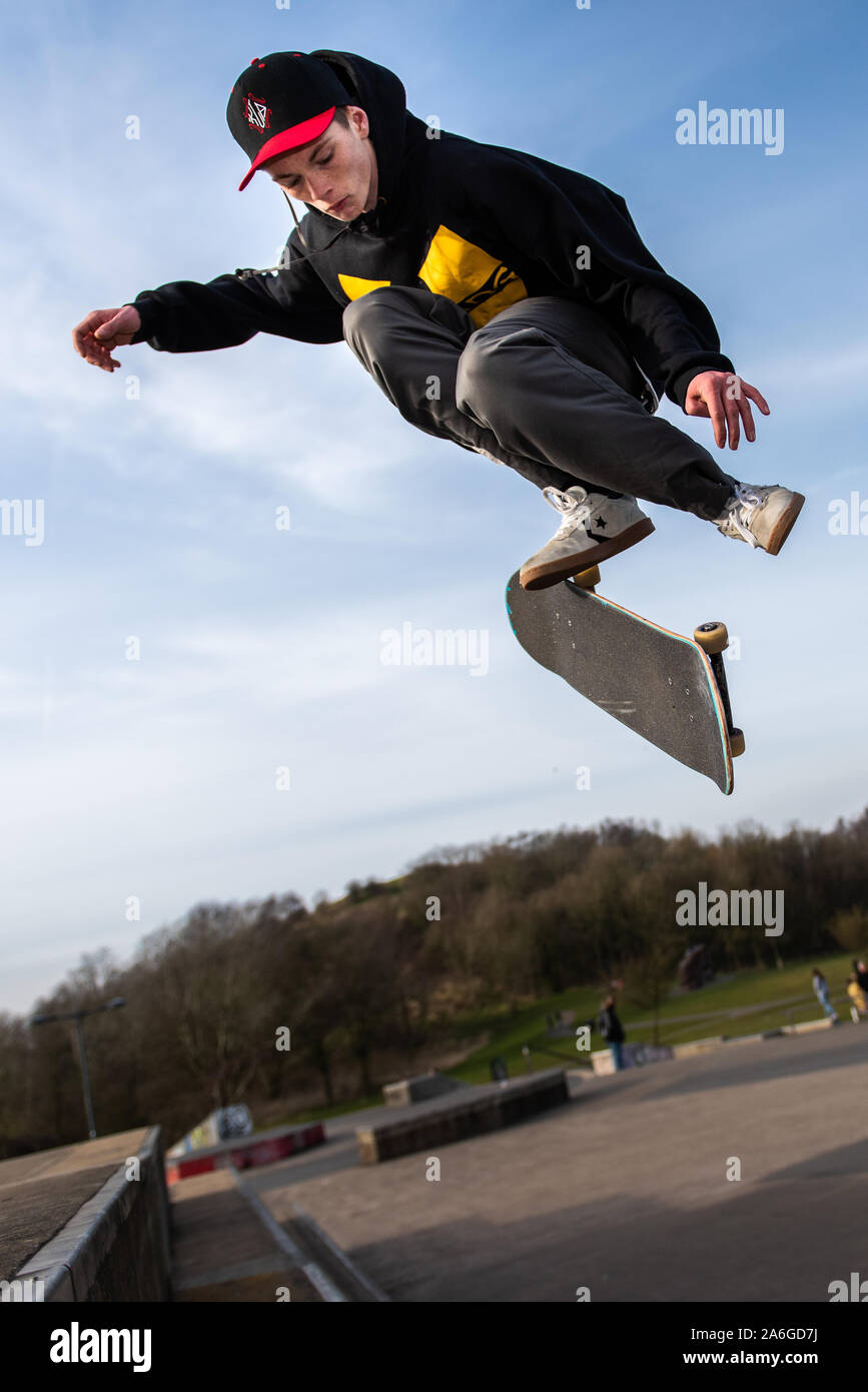 A skateboarder Ollie's off a very high double step at the skate park ...
