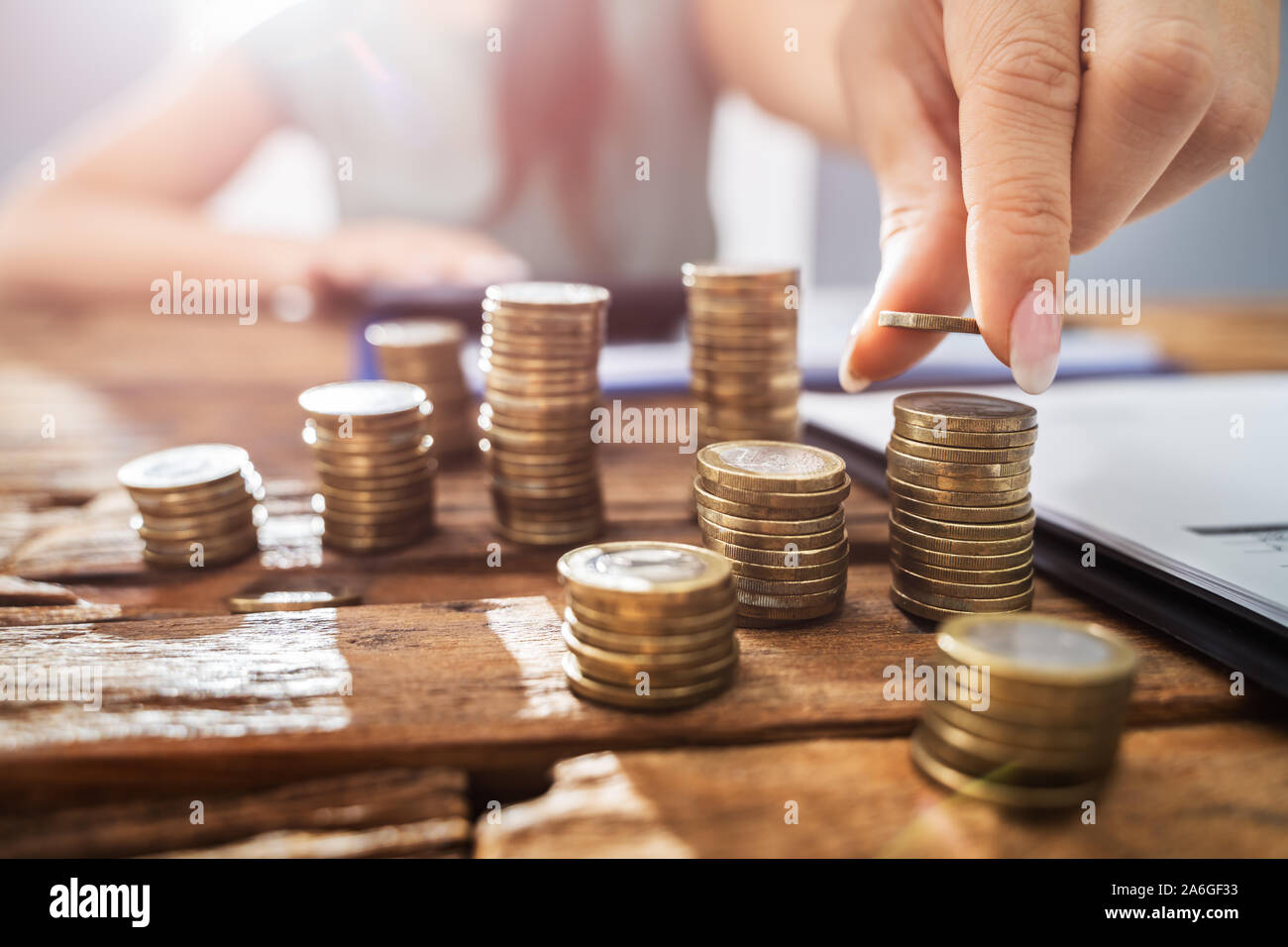 Person Hand Doing Calculation On Stacked Coins At Wooden Desk. Income ...