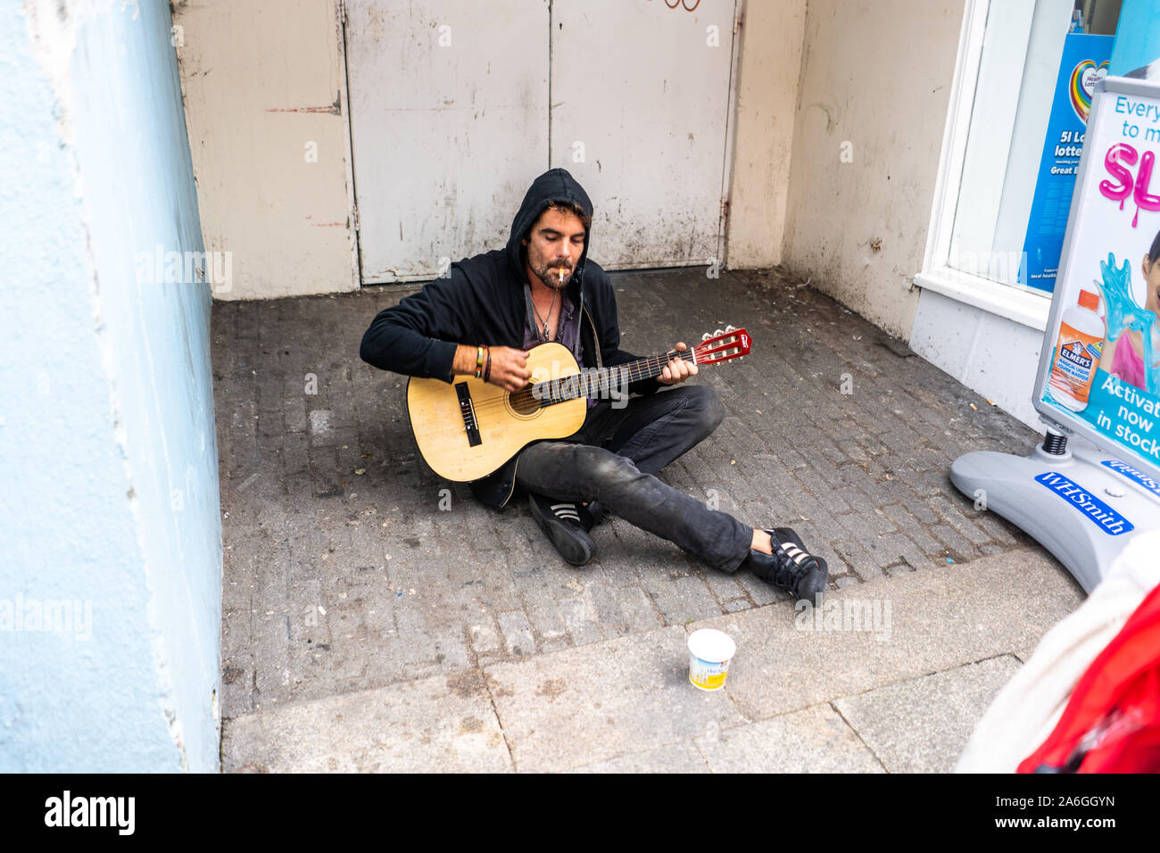 A homeless man busting for money on the high street Stock Photo - Alamy