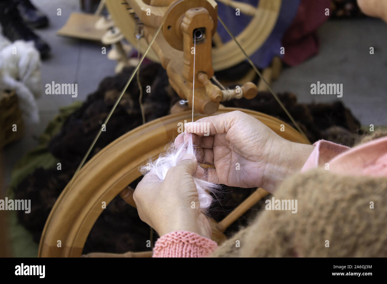 Spinning wool on sewing wheel, manufacturing and work, crafts Stock ...