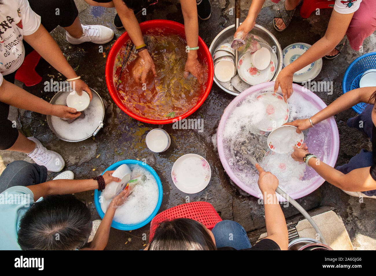 Women wash up their crockery, chopsticks and cutlery inside the Ancient ...