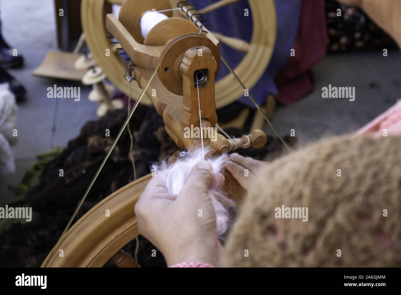 Spinning wool on sewing wheel, manufacturing and work, crafts Stock ...