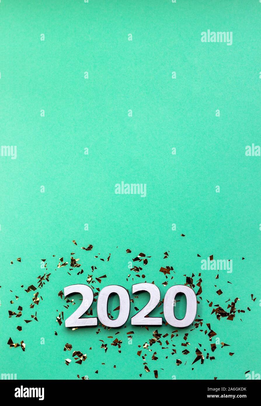 2020 white wooden letters and golden sparkles on mint backdrop. Festive ...