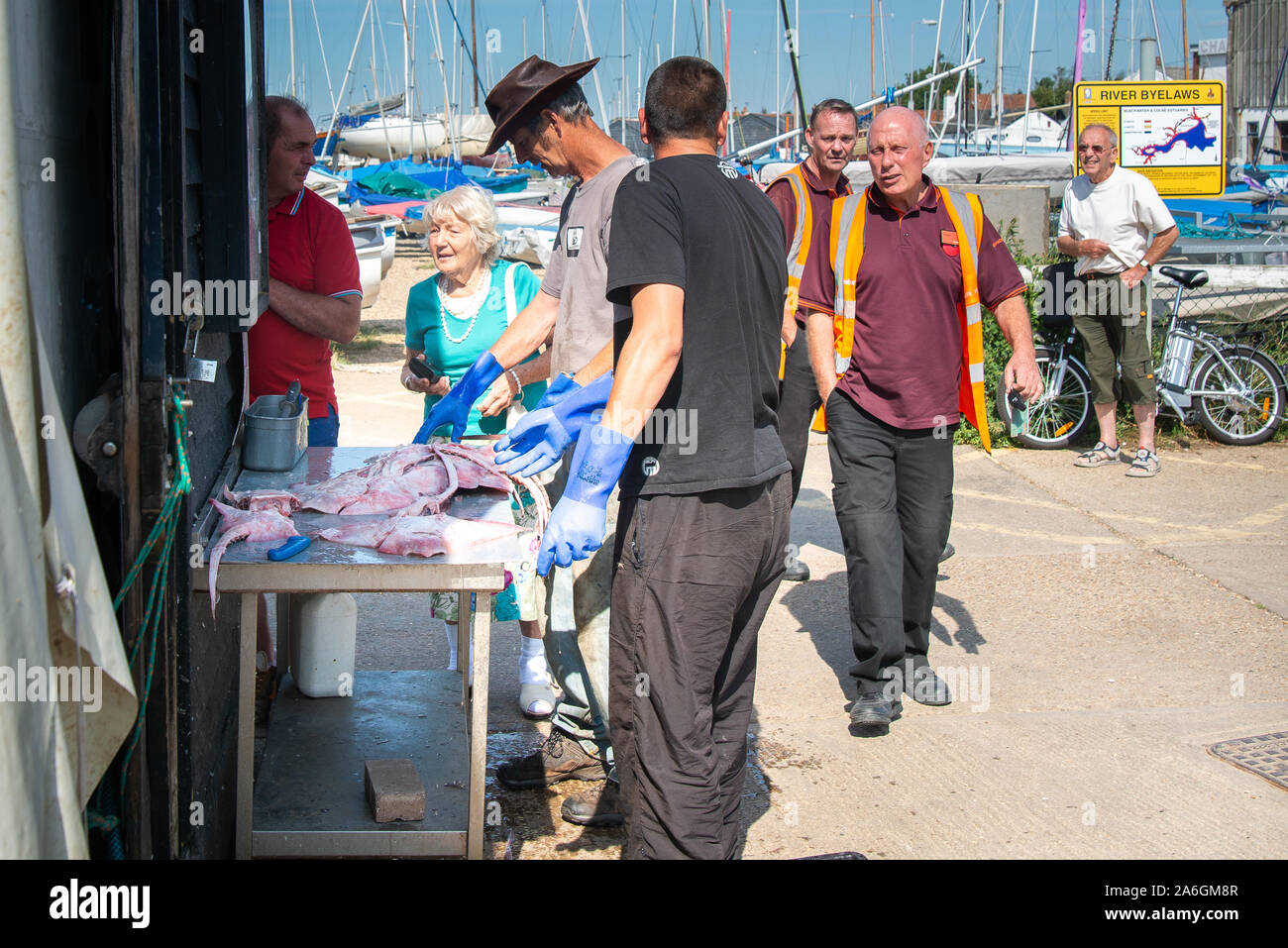 Fisherman prepare their catch of fresh fish ready for waiting customers ...