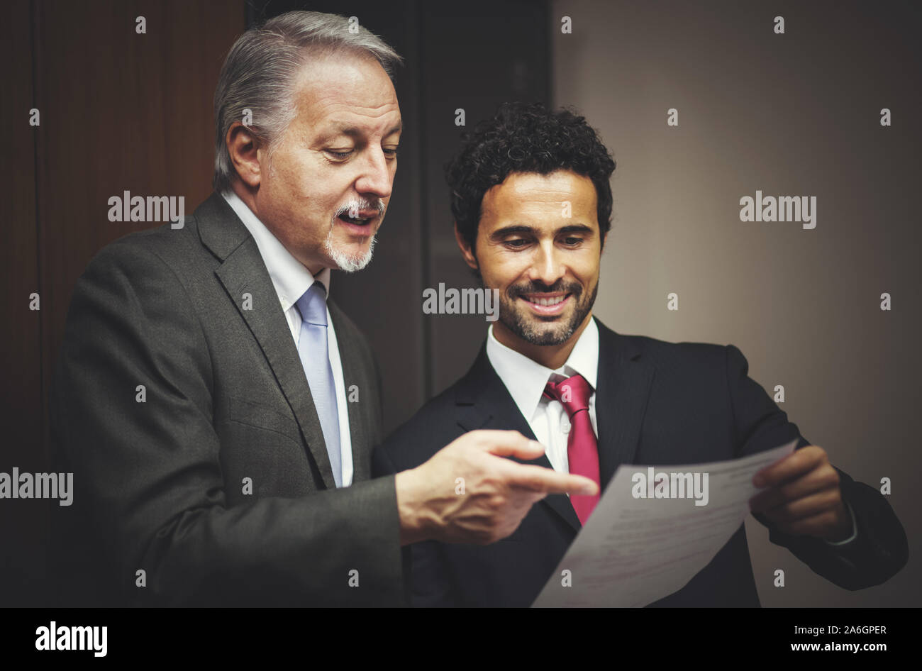 Businessman showing a document to his colleague Stock Photo - Alamy