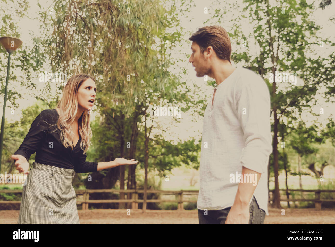 Angry young woman with her boyfriend arguing in a park Stock Photo - Alamy