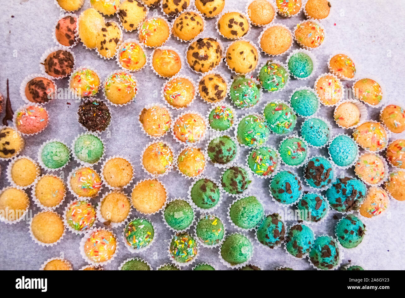 Tray with small muffins with colored topping Stock Photo - Alamy