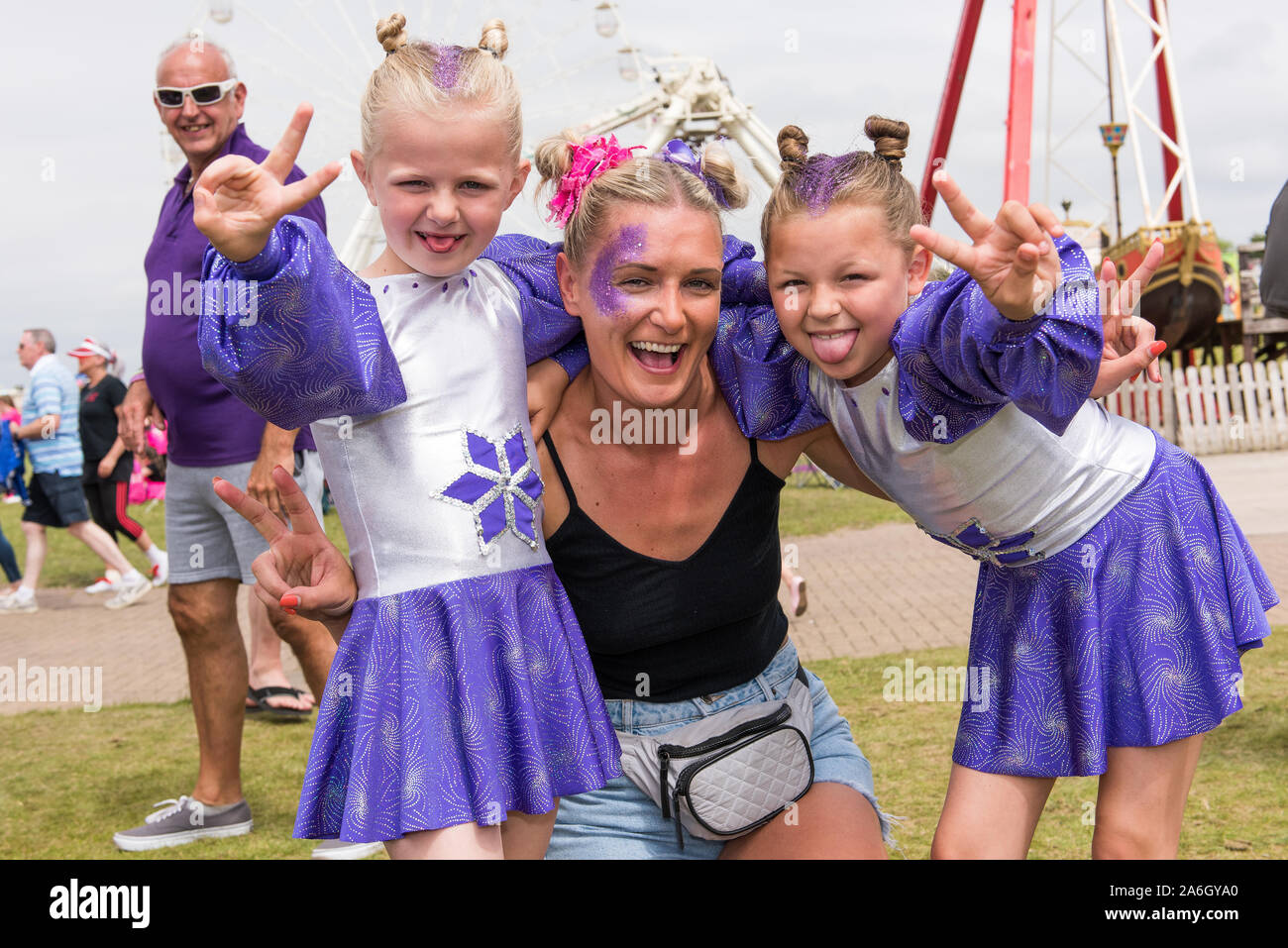 Two little dancer troupe girls posing for a picture with their trainer ...