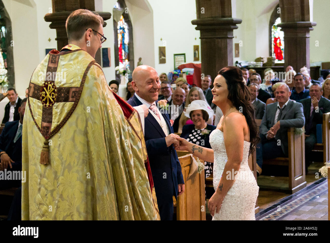 A priest, father stands in his local church performing a marriage ...