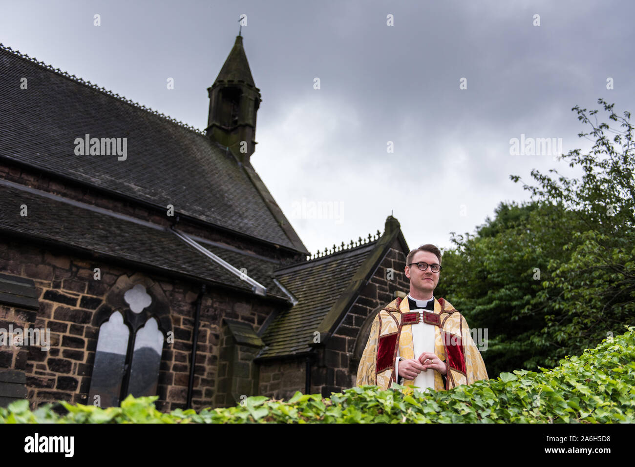 A priest, father stands outside his local church Stock Photo - Alamy