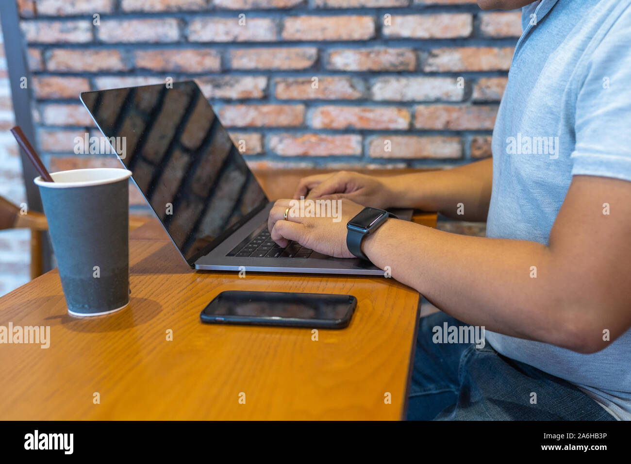 Human hand typing laptop next to coffee cup and smartphone Stock Photo ...