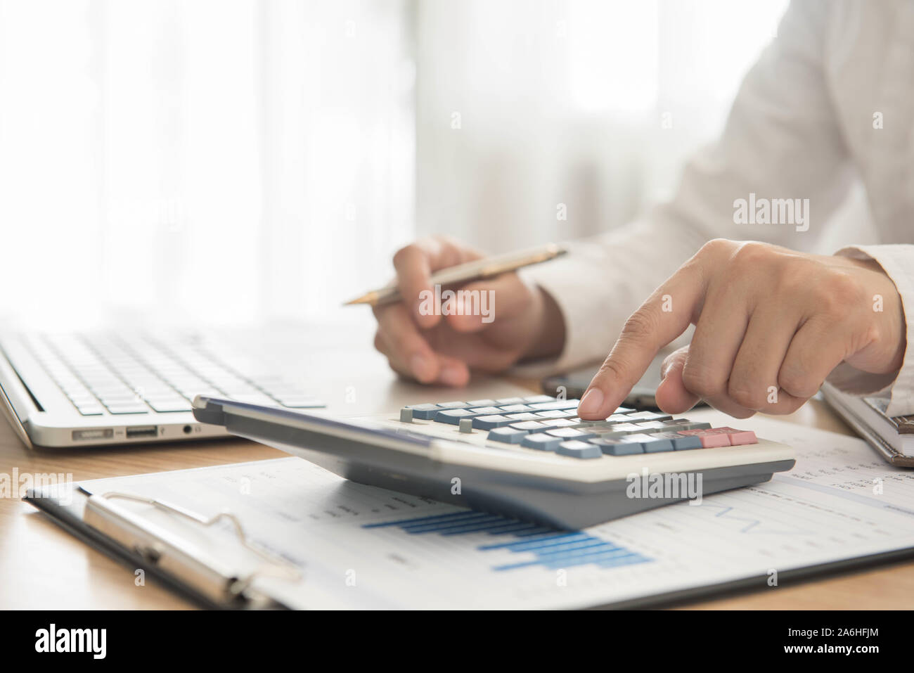 Businessman using a calculator to calculate the numbers Stock Photo - Alamy