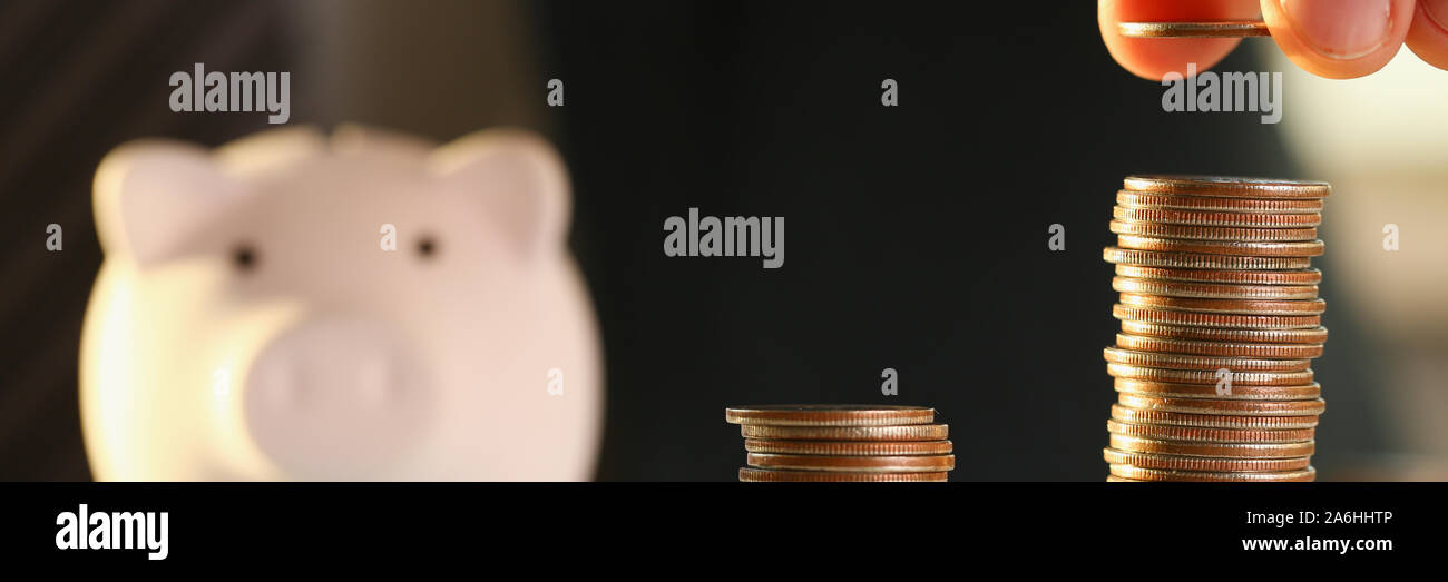 Hand businessman putting pin money into pig Stock Photo - Alamy