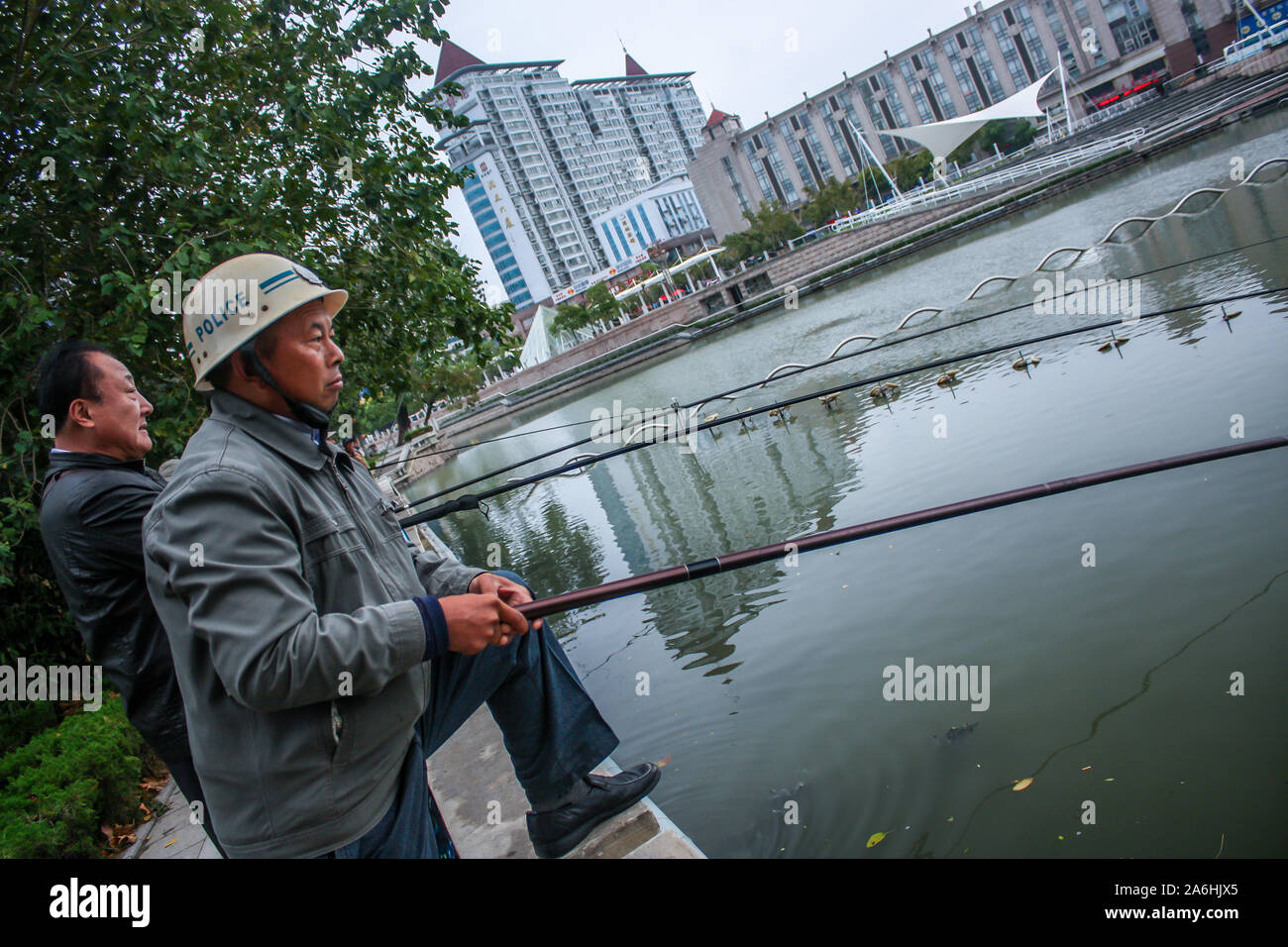 One Asian Chinese man fishing in pond in city Stock Photo - Alamy
