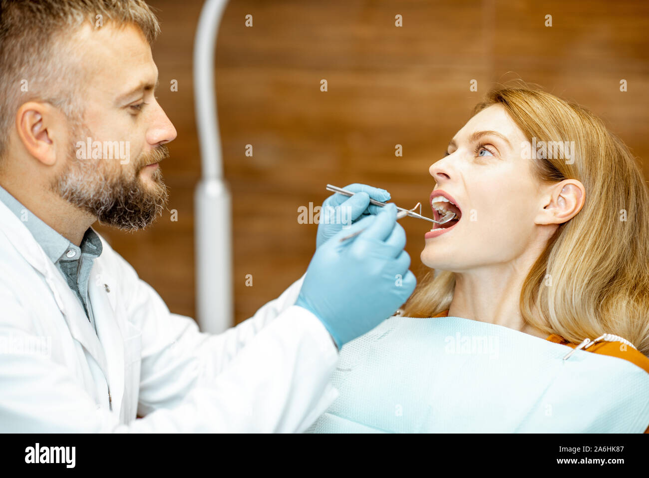 Beautiful woman as a patient during a teeth inspection with a senior ...