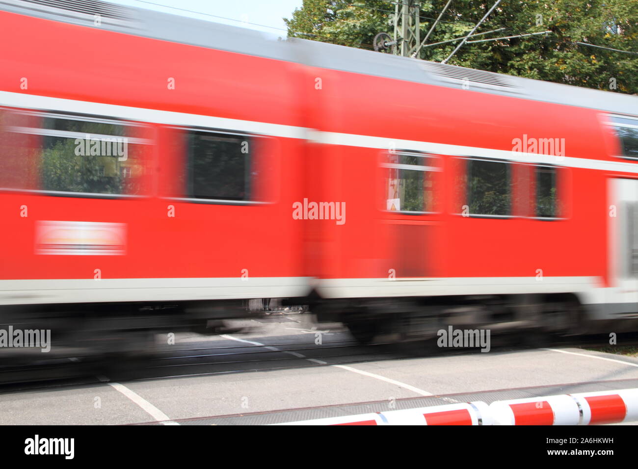 A red train at a railroad crossing Stock Photo - Alamy
