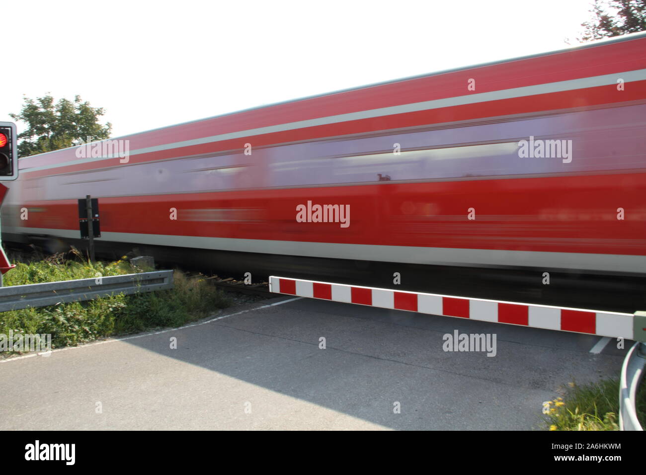 A red train at a railroad crossing Stock Photo - Alamy
