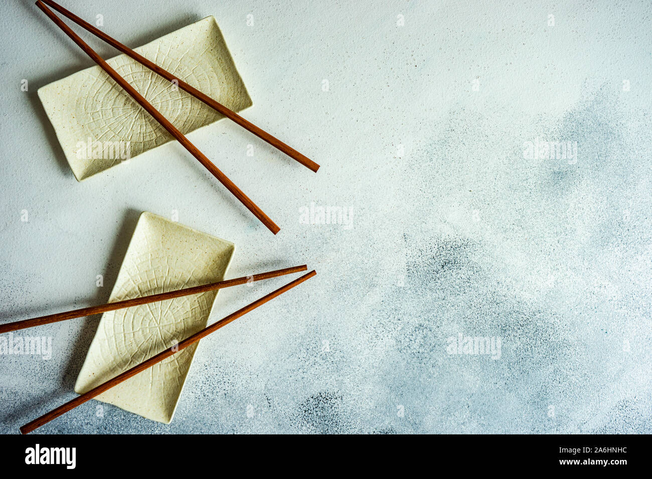 Asian table setting with ceramic bowl and wooden chopsticks on stone ...