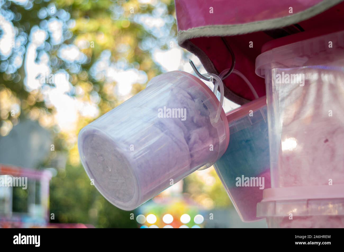 Cotton candy containers hanging from a funfair stand with blurred ...