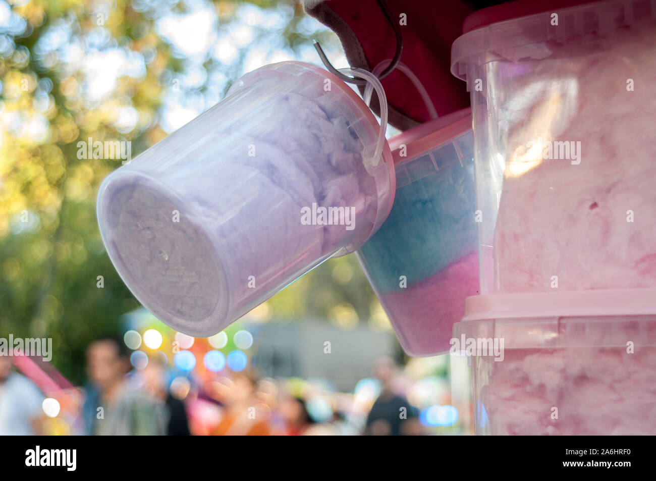 Cotton candy containers hanging from a funfair stand with blurred ...