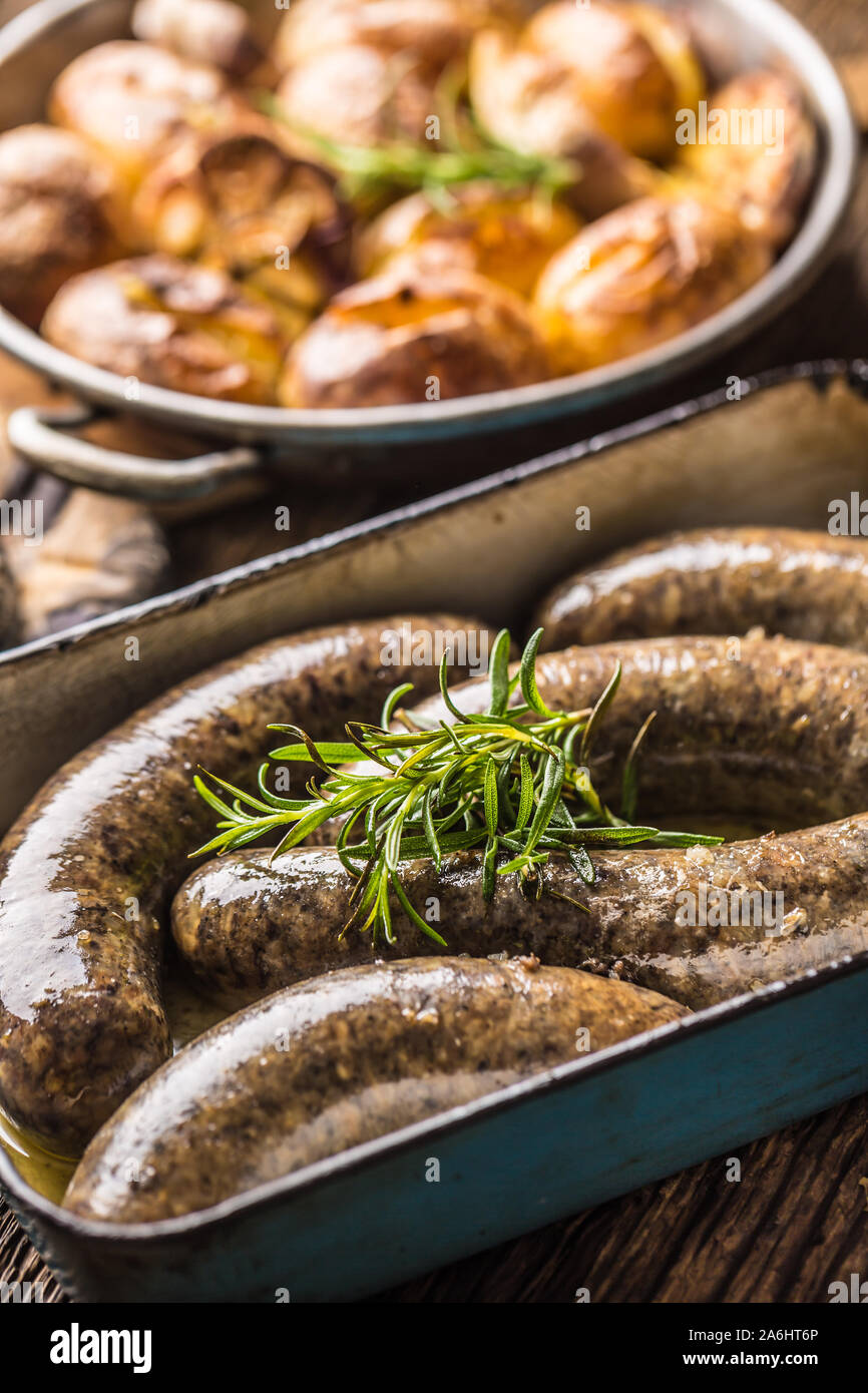 Roasted sausages in pan with rosemary and potatoes.. Traditional ...
