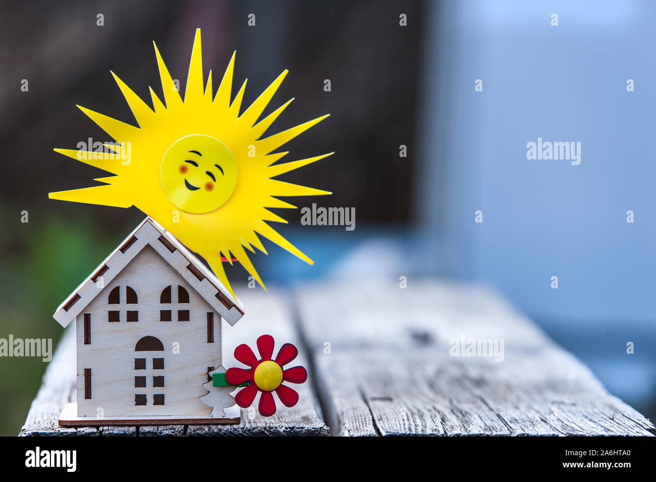 Toy house with a sun on a beautiful background. Symbol of happiness ...