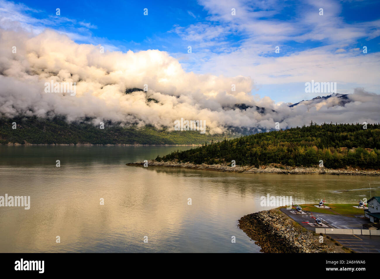 Clouds form a ridge over Skagway harbor, Alaska, with helipad in ...